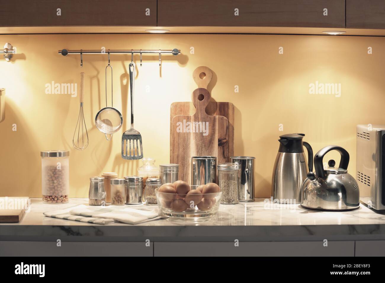 some kitchenwares and ingredient bottles put on the counter and hanging ...