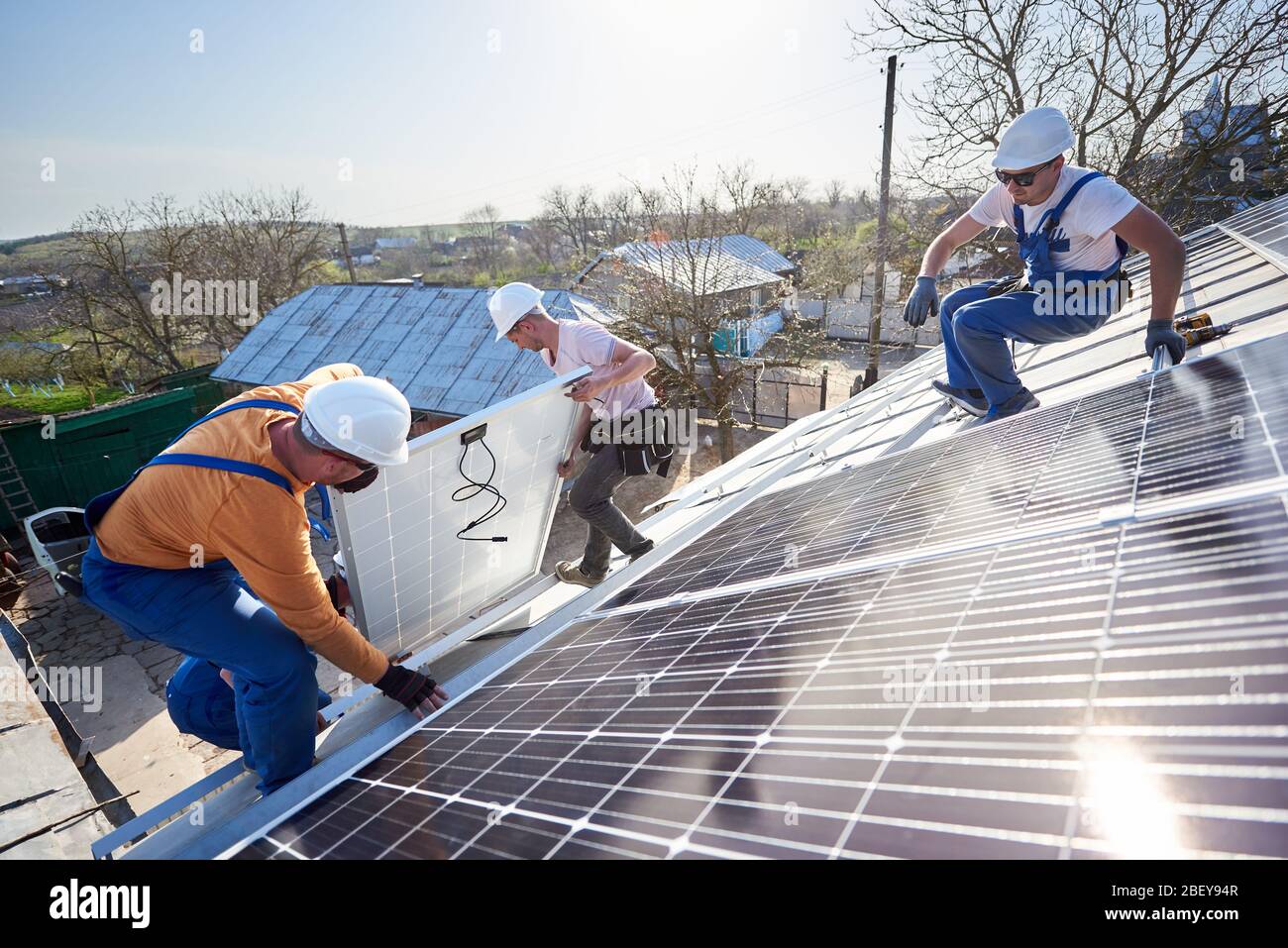 Male team workers installing solar photovoltaic panel system ...