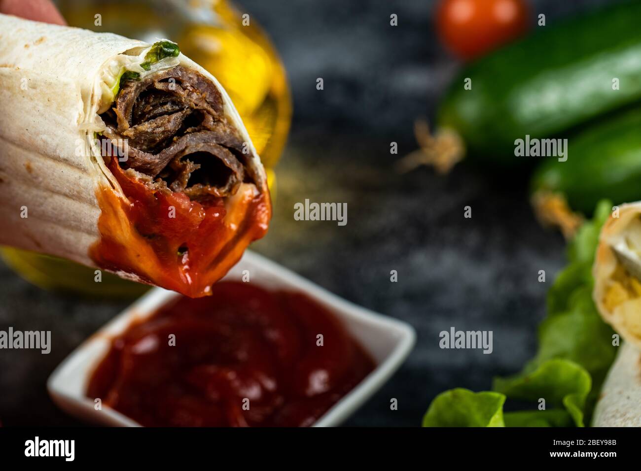 Meat shaurma roll,arabic street food dipped in ketchup Stock Photo - Alamy