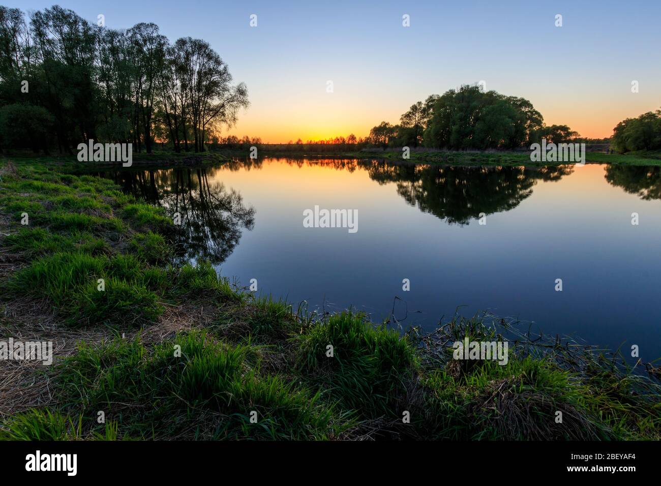 Scenic view of beautiful sunset above the river at summer evening with ...