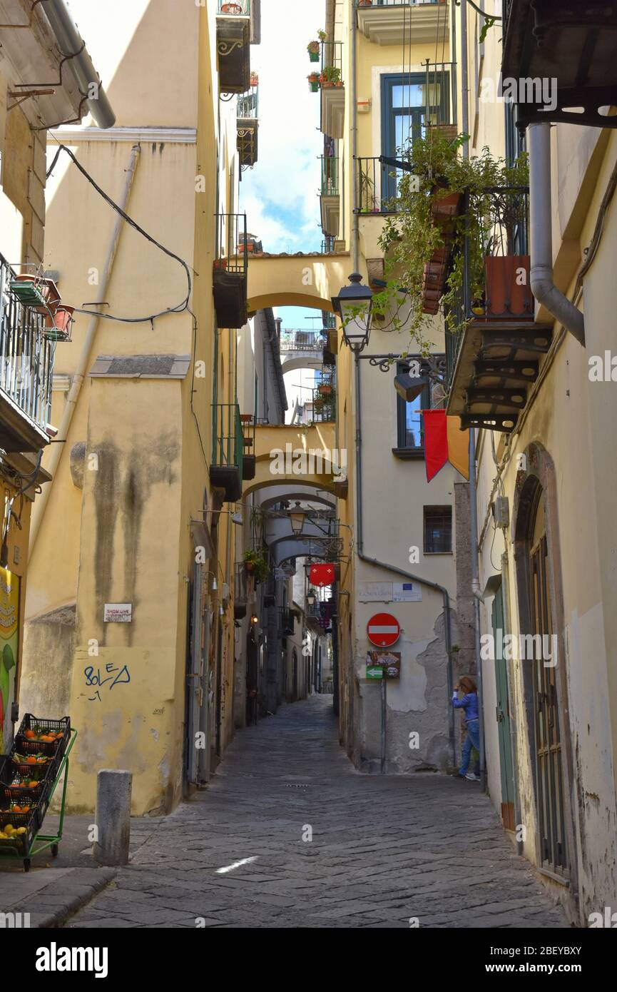 A narrow street between the old houses of Salerno, a city in the ...