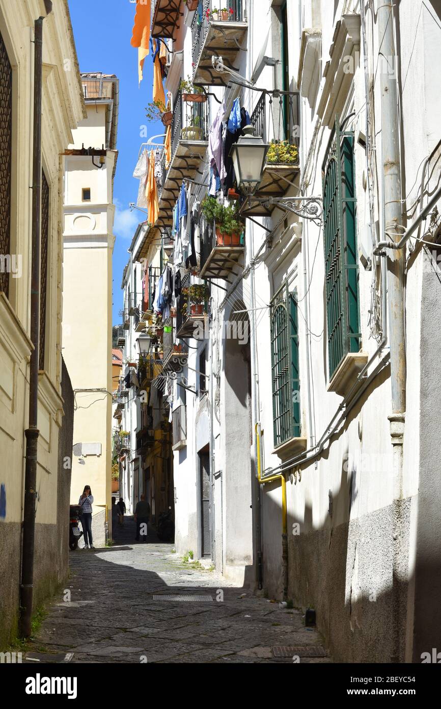 A narrow street between the old houses of Salerno, a city in the ...