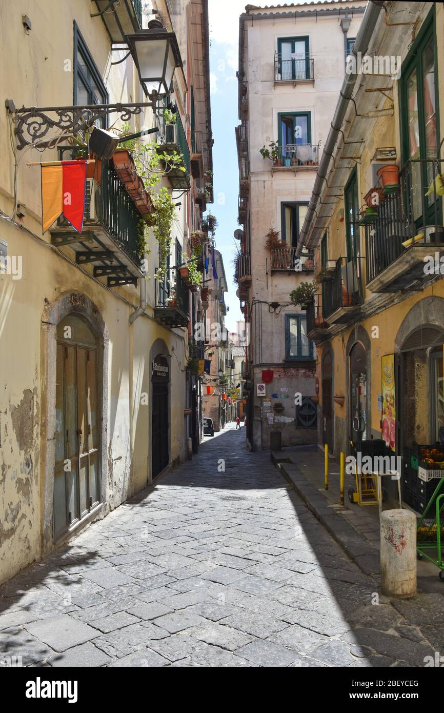 A narrow street between the old houses of Salerno, a city in the ...