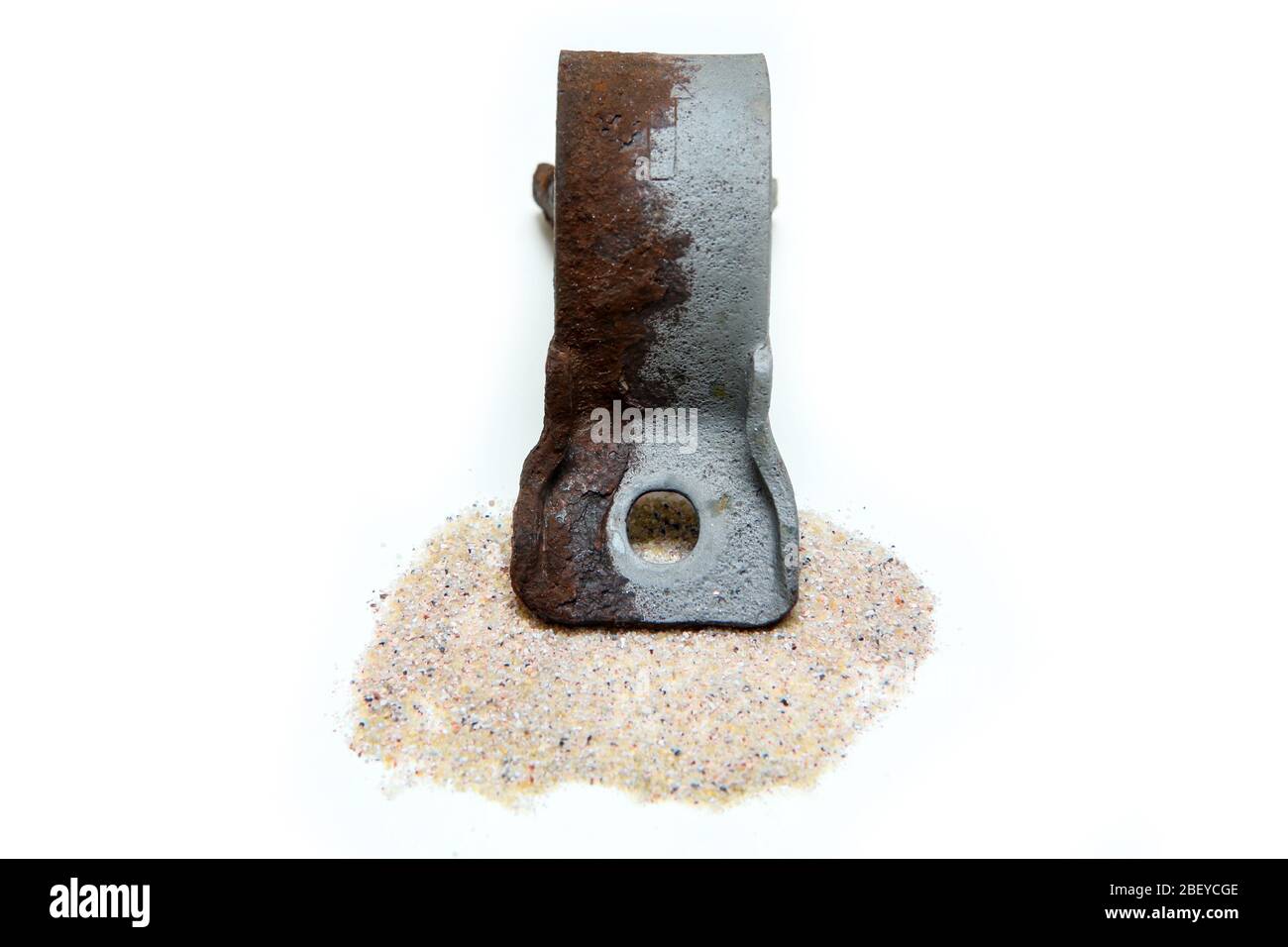 The overgrown rusty cast iron part partly sand blasted together with ...