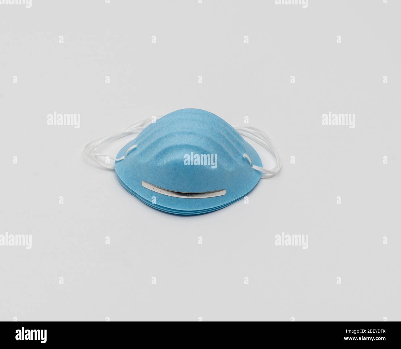 A pile of blue dust masks on white background, isolated, viewed from an ...