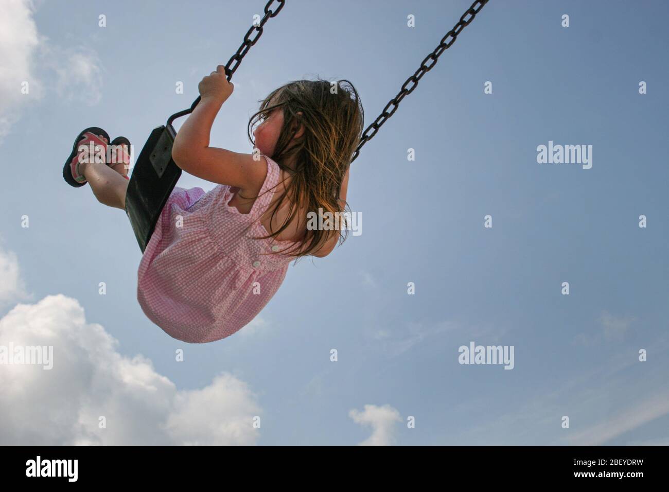 Girl swinging high on a swing Stock Photo - Alamy