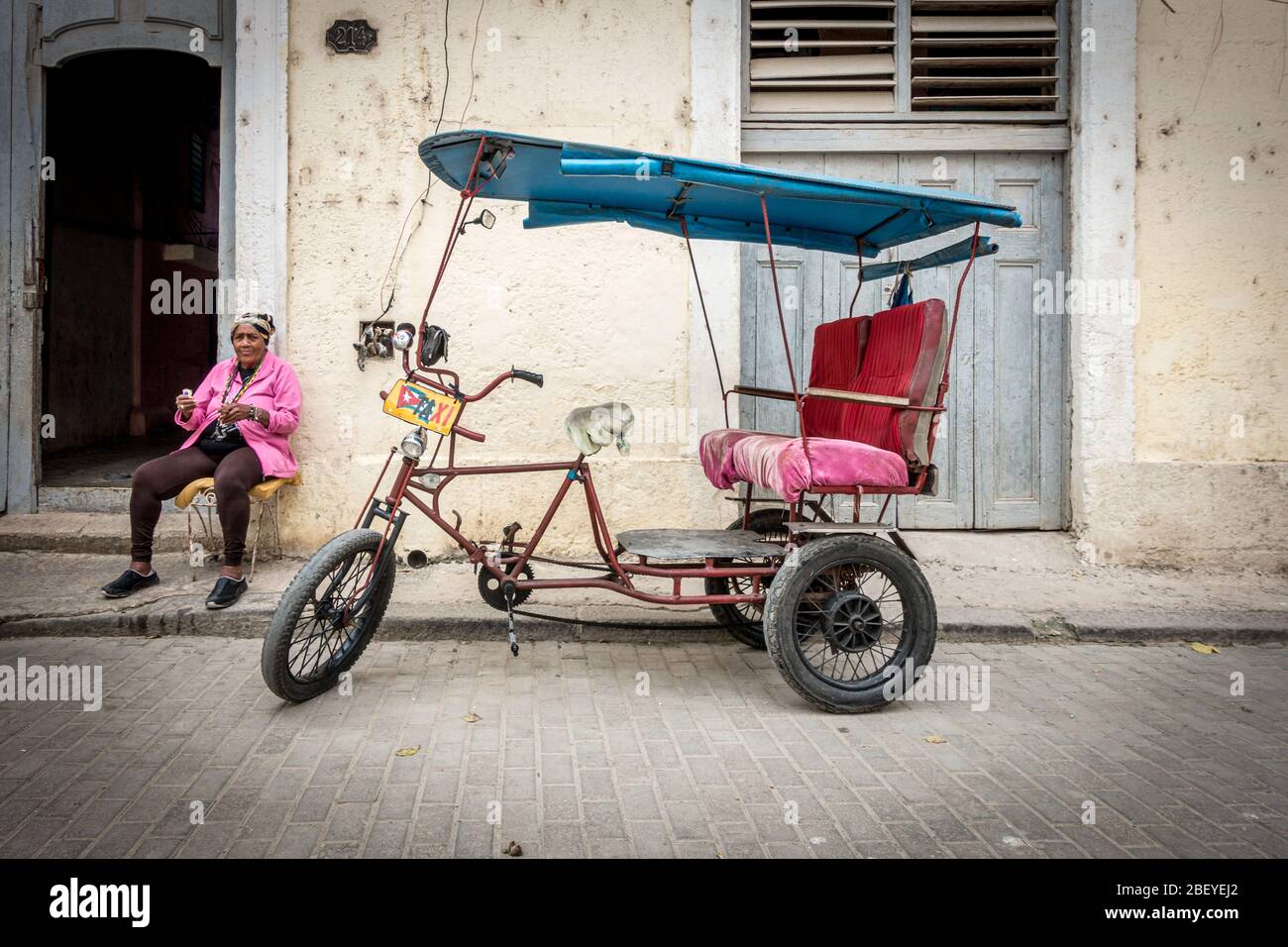 Uncluttered view of a Cuban rickshaw taxi with female taxi driver ...