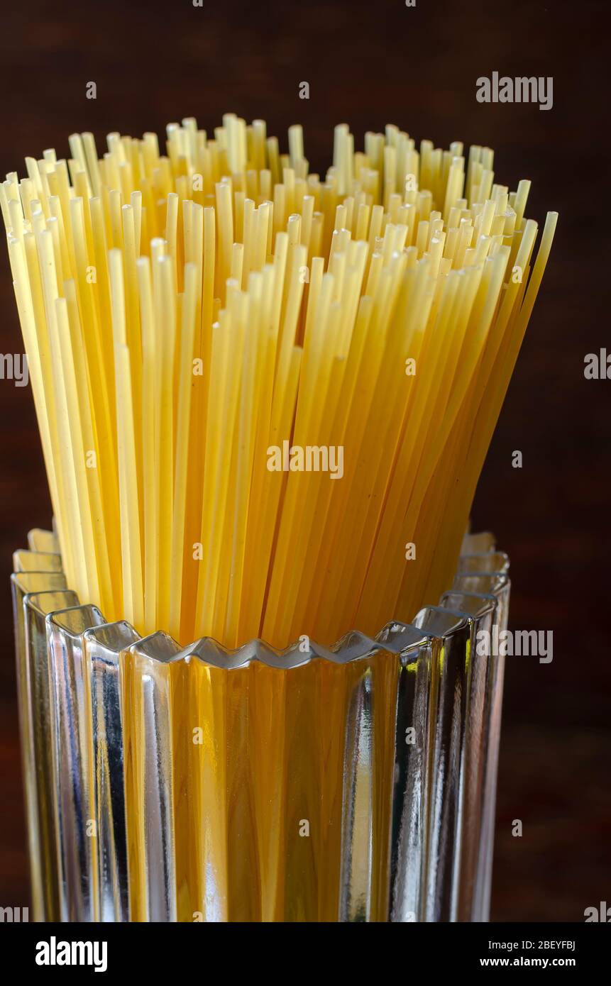 Uncooked spaghetti in a glass bowl. Unprepared spaghetti in the sun ...