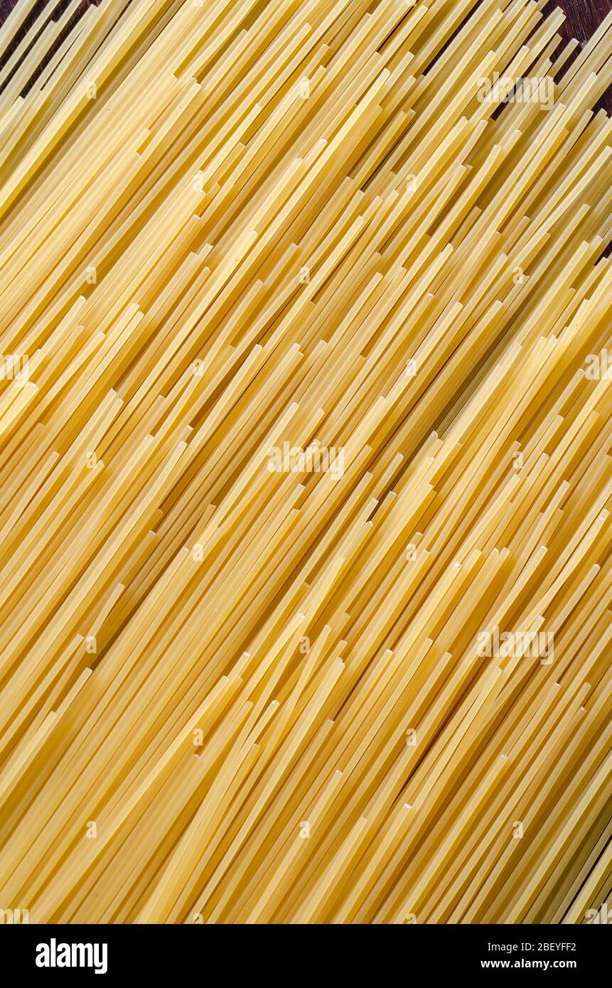 Raw spaghetti background. Unprepared spaghetti on a dark wooden table ...