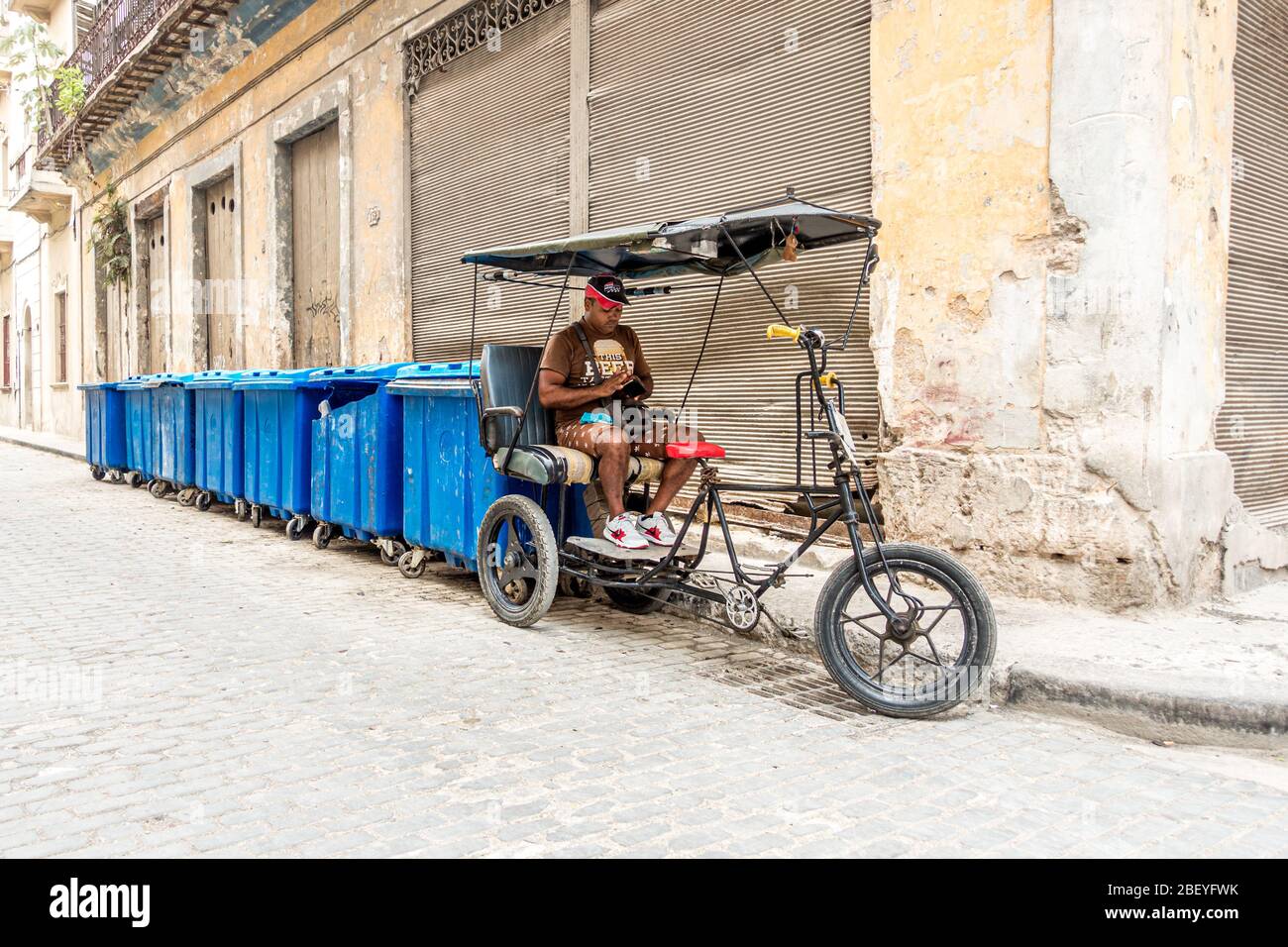 Uncluttered view of a Cuban rickshaw taxi with male taxi driver ...