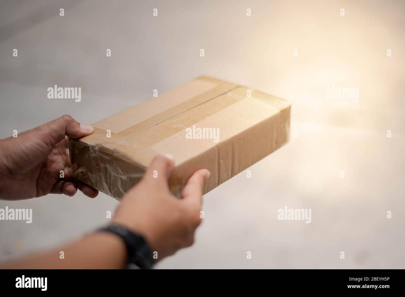 Delivery man hand carrying cardboard box packaging for logistic ...