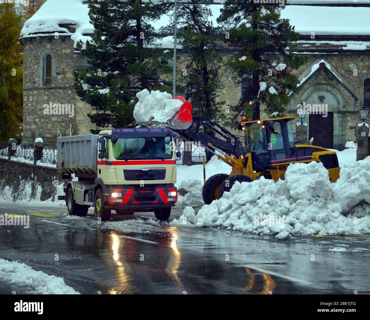 Snow cleaning tractor snow-removal machine loading pile of snow on a ...