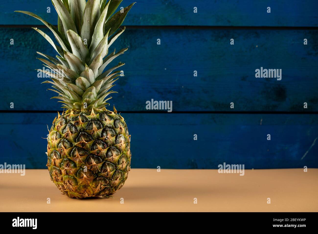 Pineapple isolated on the orange color table Stock Photo - Alamy