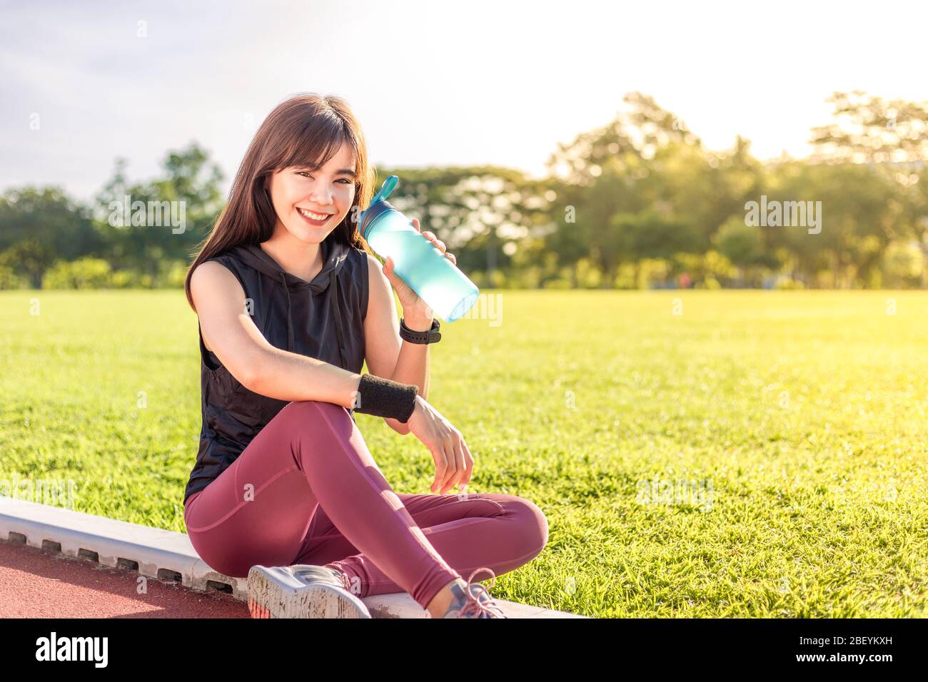 Beautiful young Asian woman exercising in the morning at a running ...