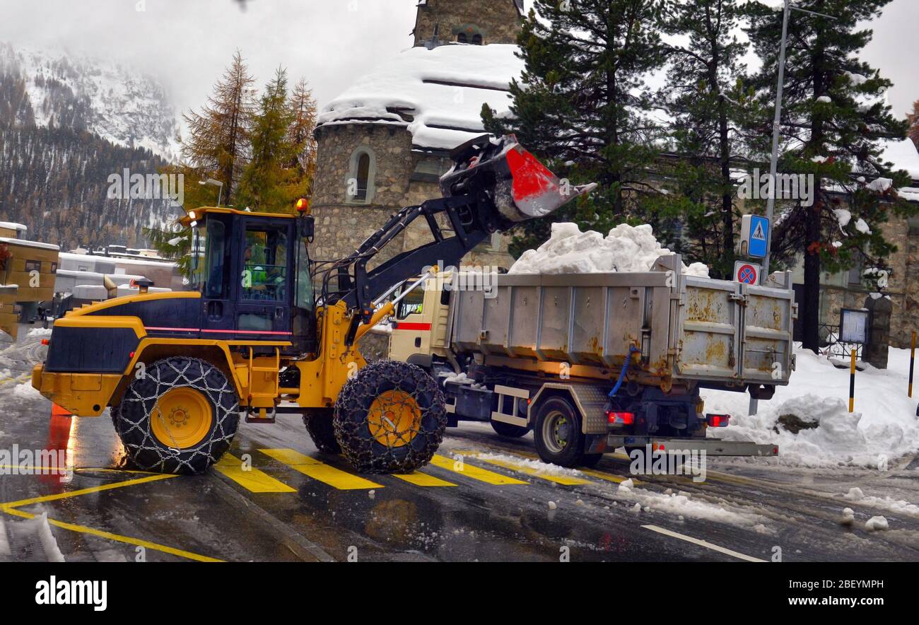Snow cleaning tractor snow-removal machine loading pile of snow on a ...