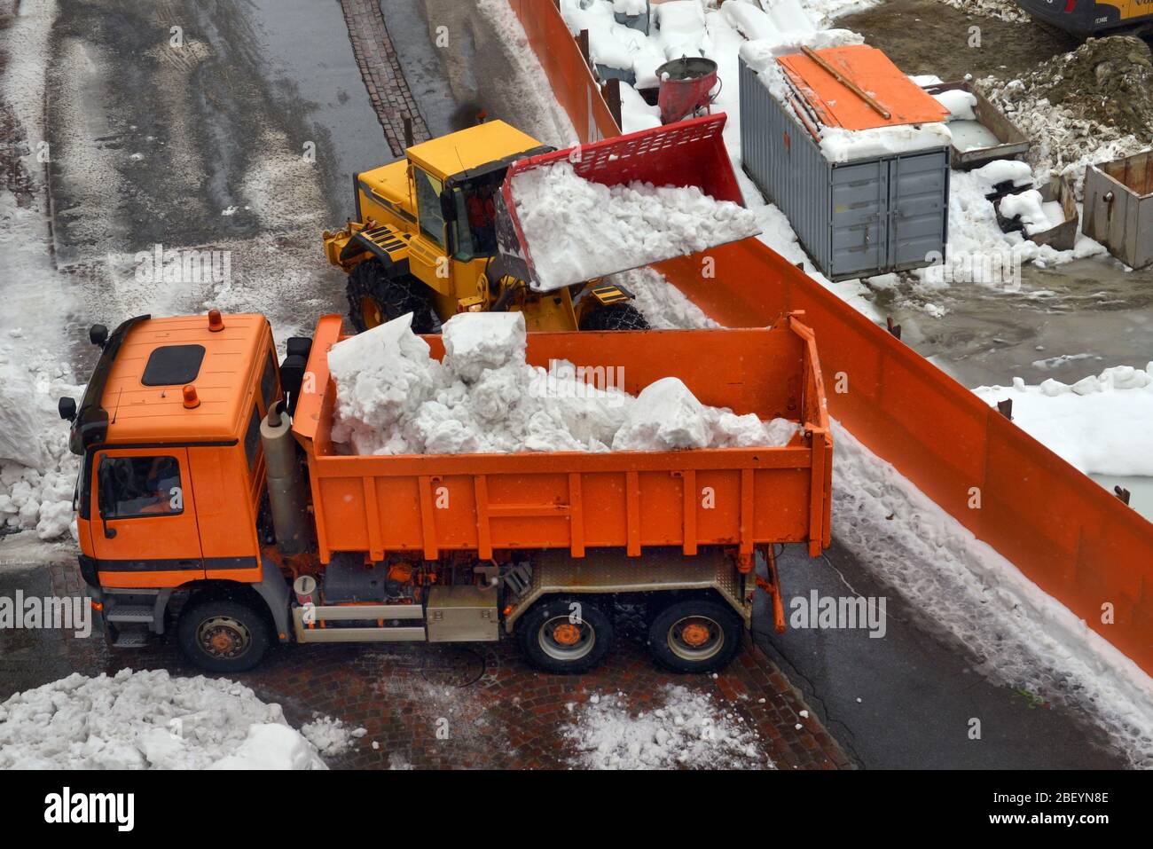 Snow cleaning tractor snow-removal machine loading pile of snow on a ...
