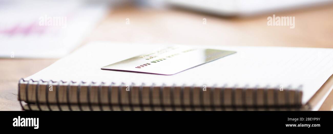 Table in bank notepad with spring and credit card Stock Photo - Alamy