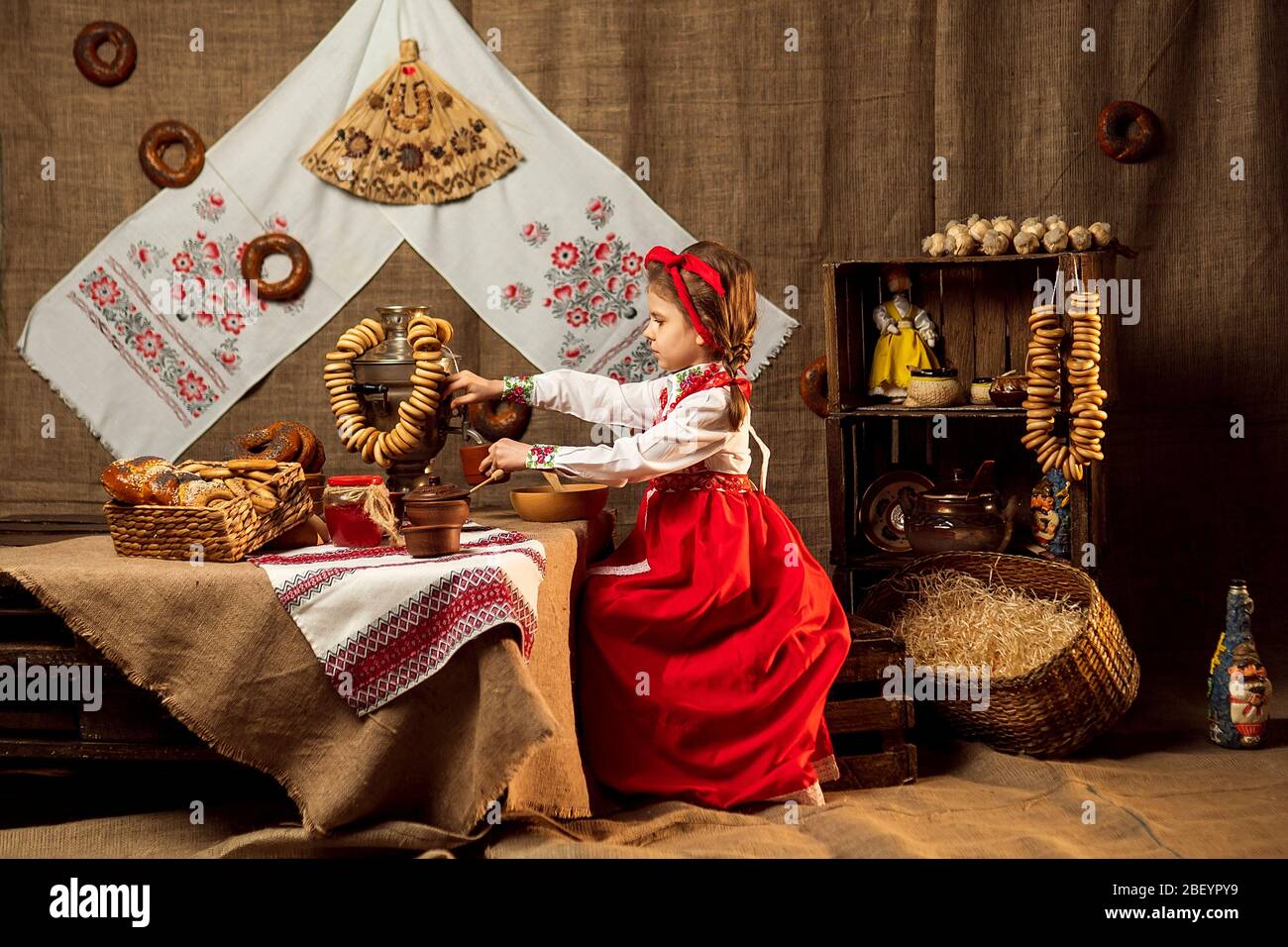 Happy curly child girl sitting on stump and eating watermelon outdoors ...