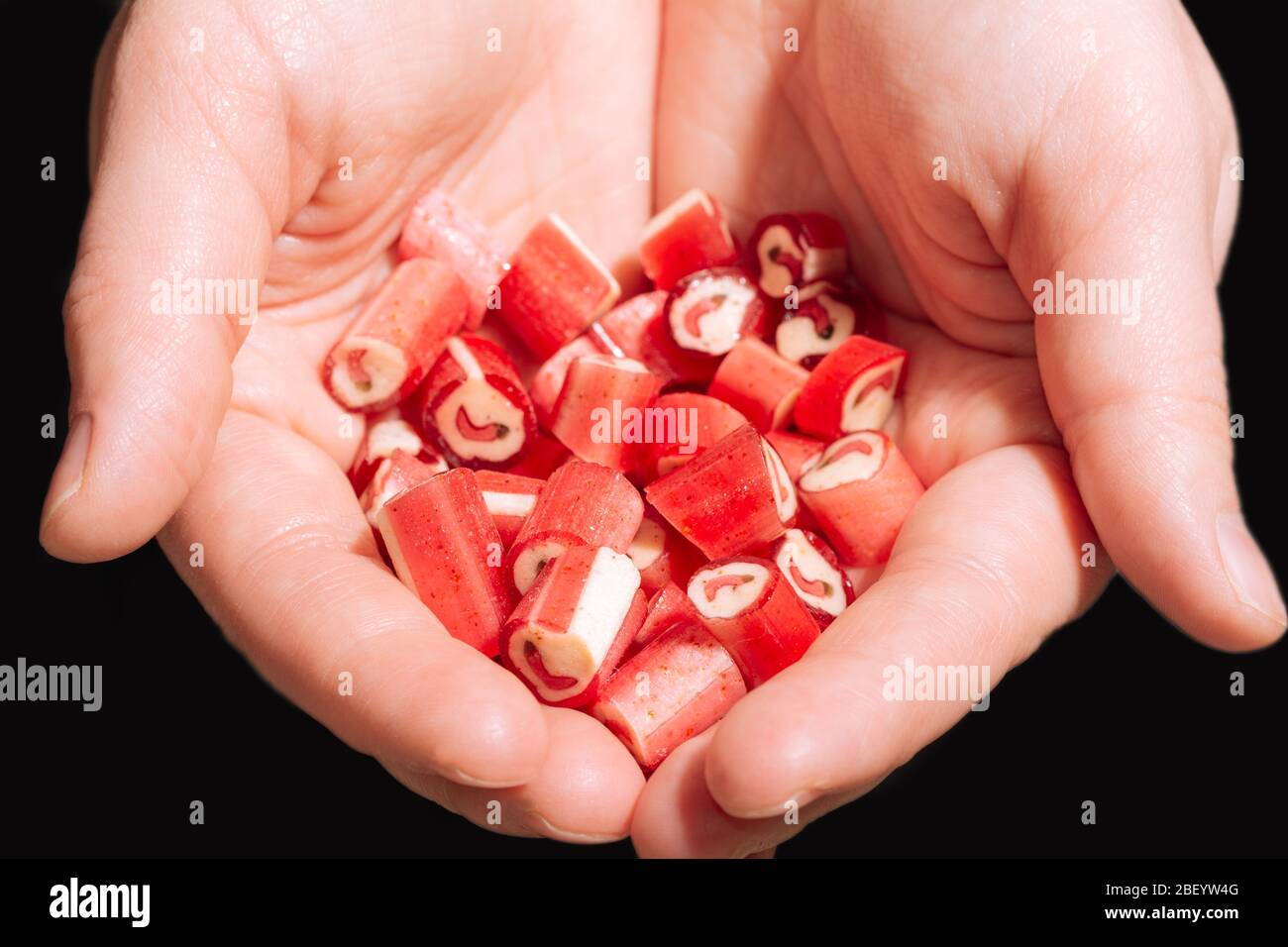 handful of handmade red chilli lollipops with pepper image in the hands ...