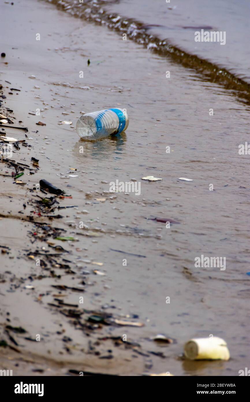 Plastic water bottle trash on a bay polluting the ocean. Plastic trash ...