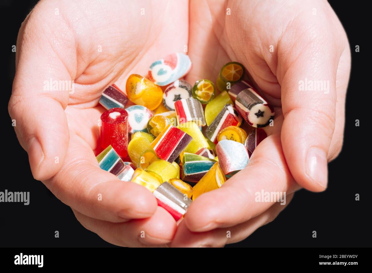 Big handful of handmade mix lollipops multicolored in the hands of ...