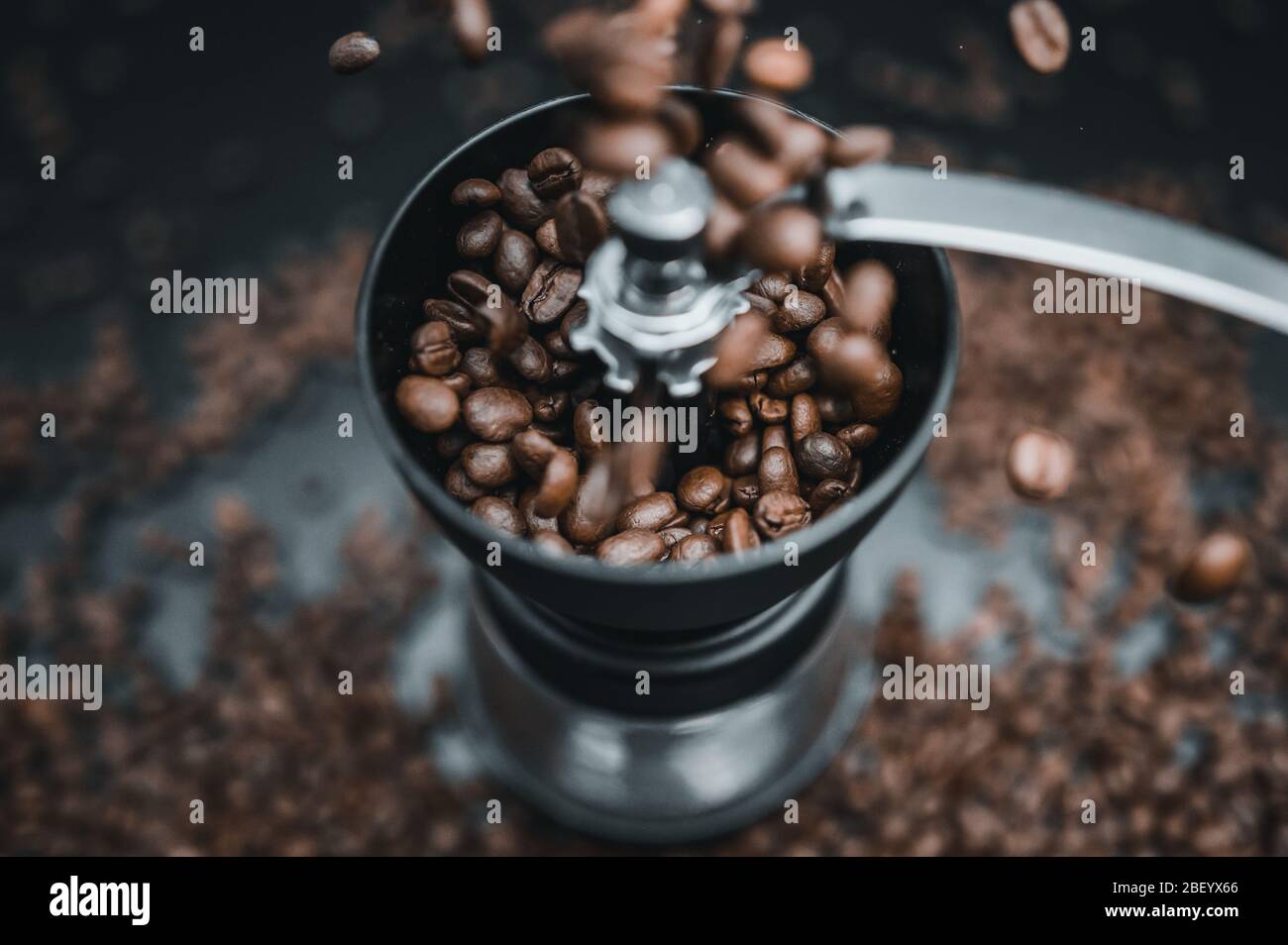 Fried coffee beans are falling to manual grinder. Cinematic dark colors ...