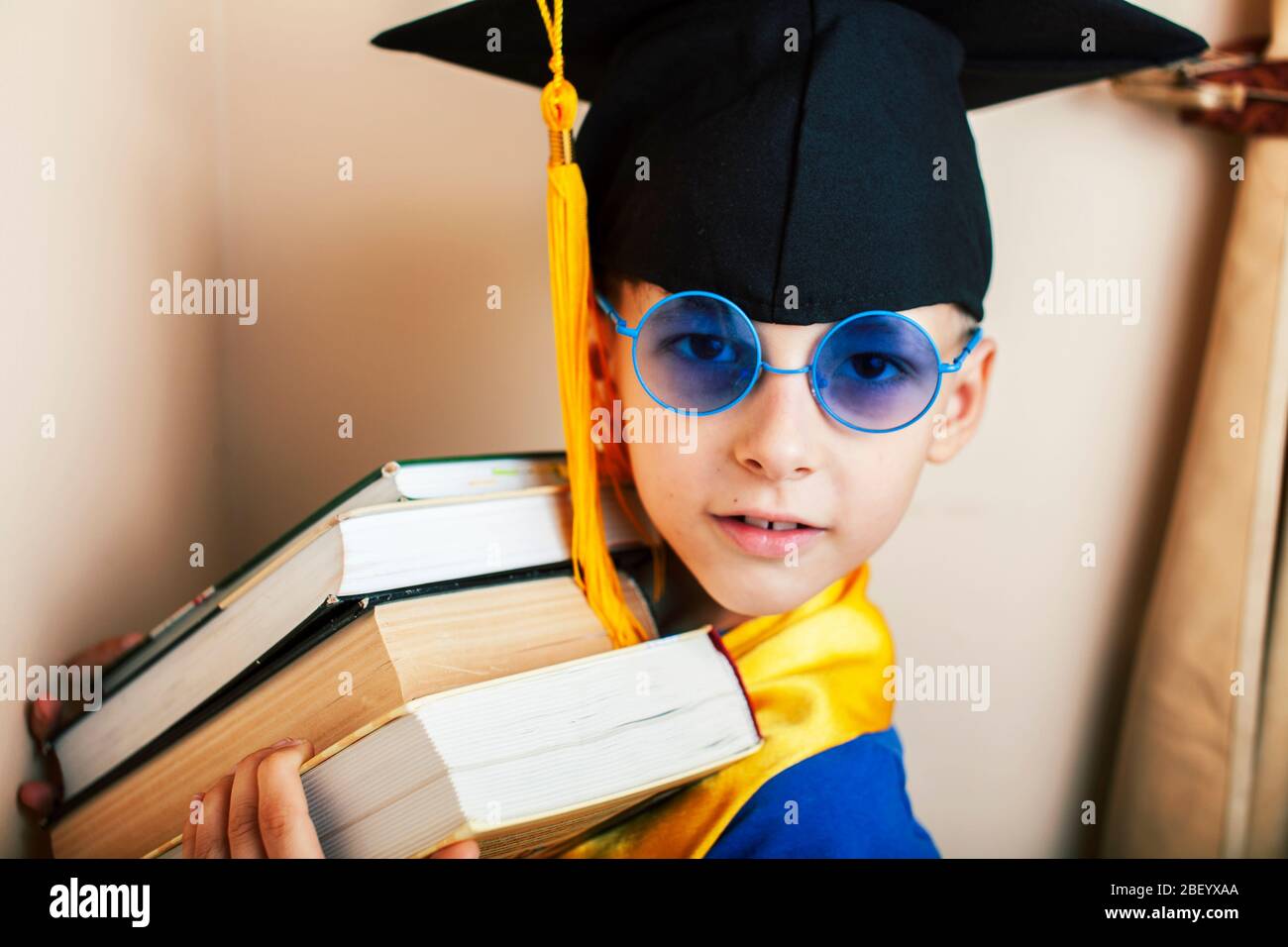 little cute preschooler boy in glasses with books at home education in ...