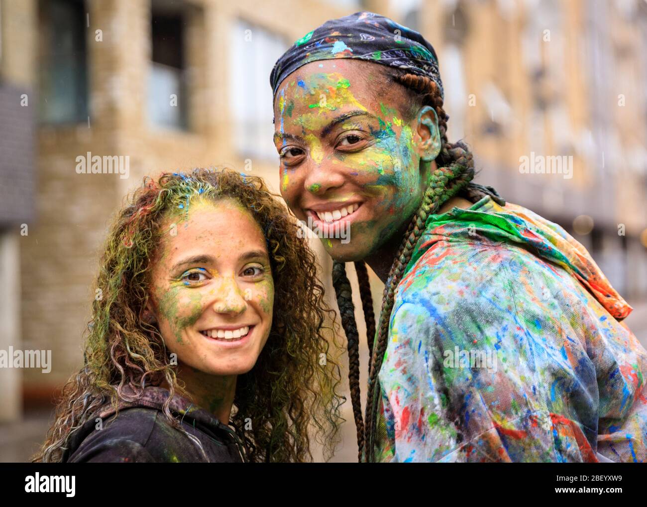 Participant with decorated face and flower head piece and revellers at ...