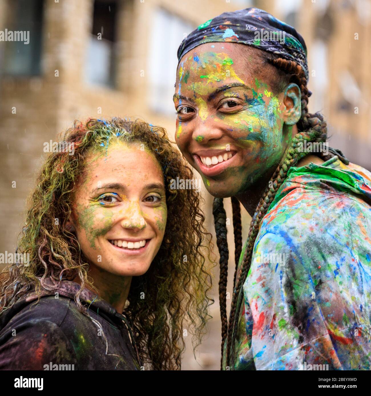 Participant with decorated face and flower head piece and revellers at ...