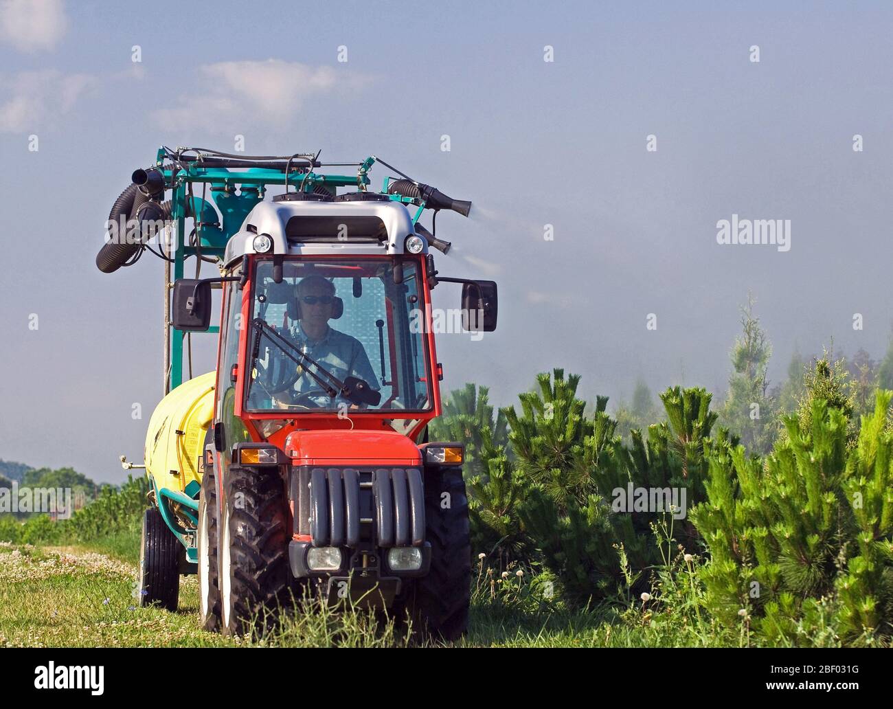2008 - Farmer driving a small tractor and pulling a small pesticide ...