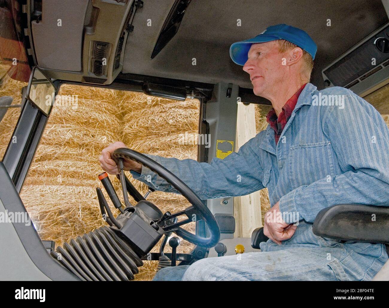 2006 - farmer driving a large tractor completing some of his daily ...