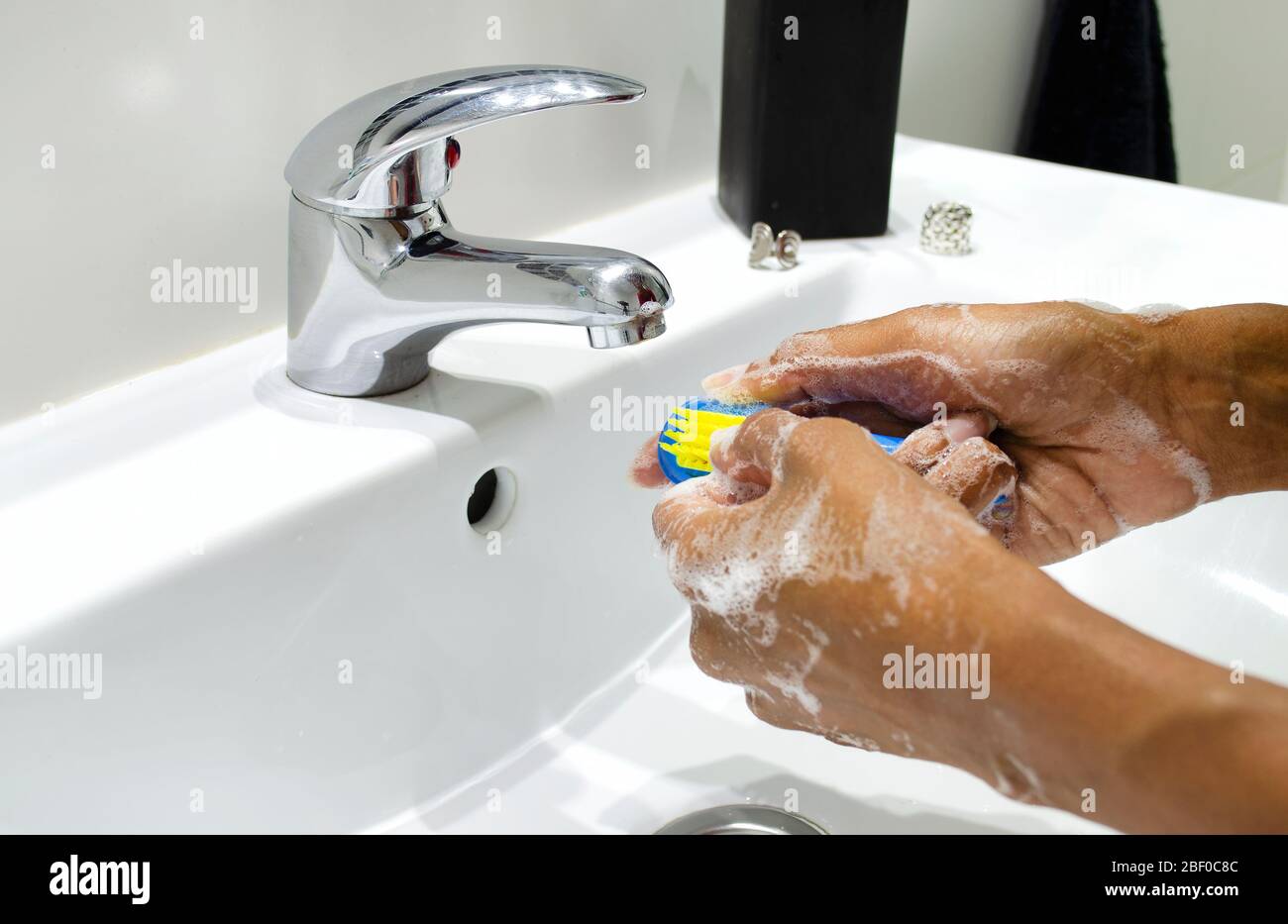 Black woman conscientiously washing her hands with soap and cleaning ...