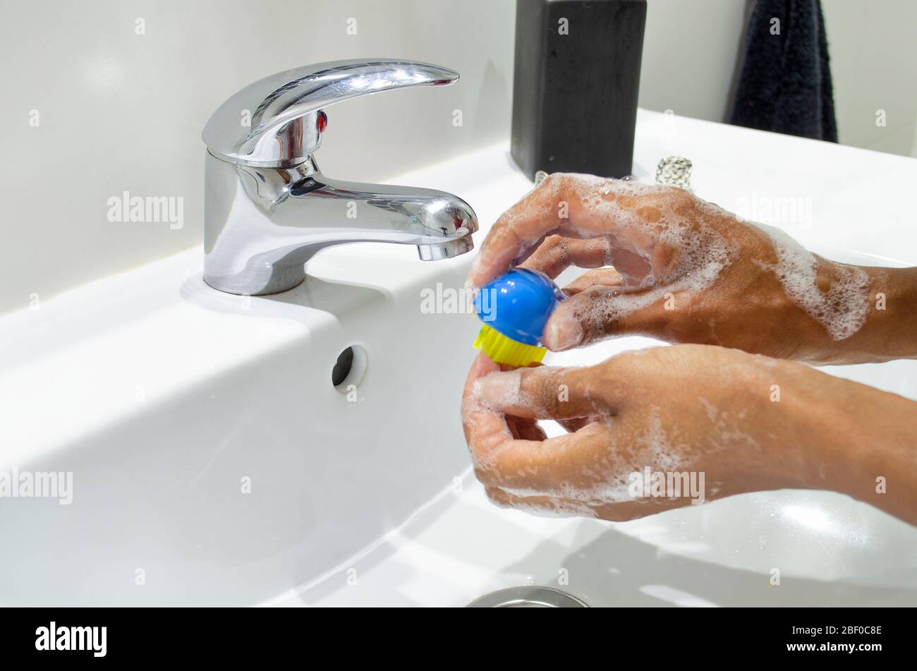 Black woman conscientiously washing her hands with soap and cleaning ...