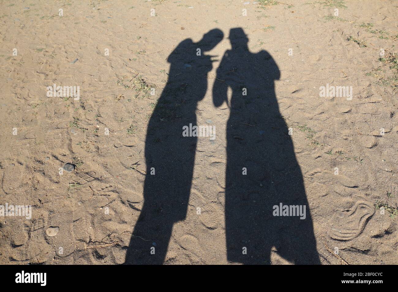Shadow of two men on the sand at the beach Stock Photo - Alamy