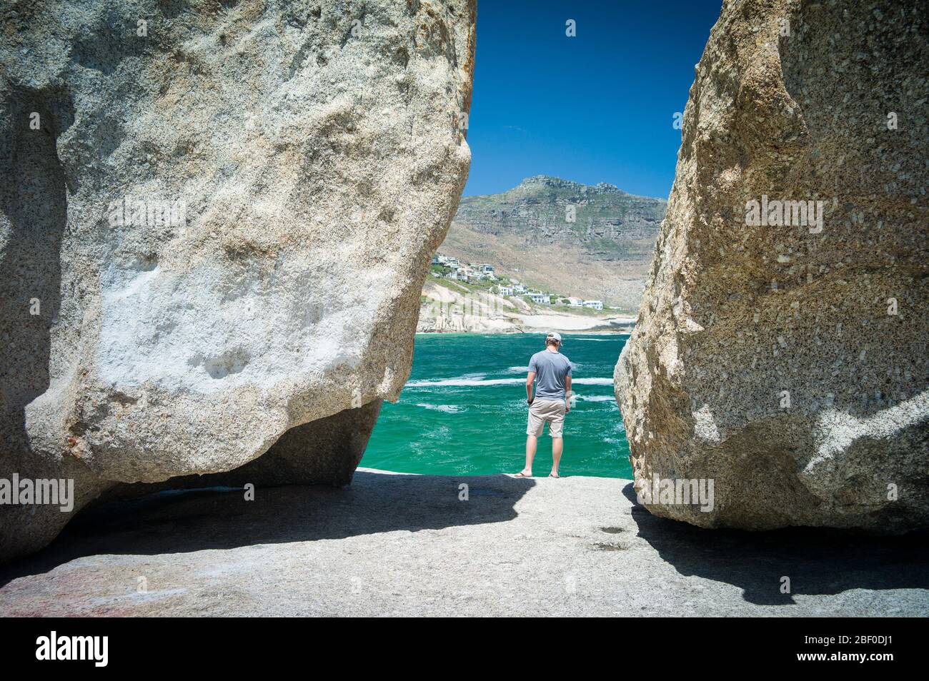 A man looks at the beautiful view of the beach at Llandudno, Cape Town ...