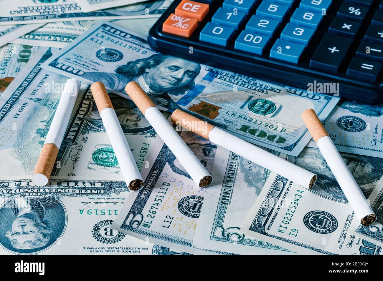 Concept of smoking cost. Cigaretes on a dollars background and black ...