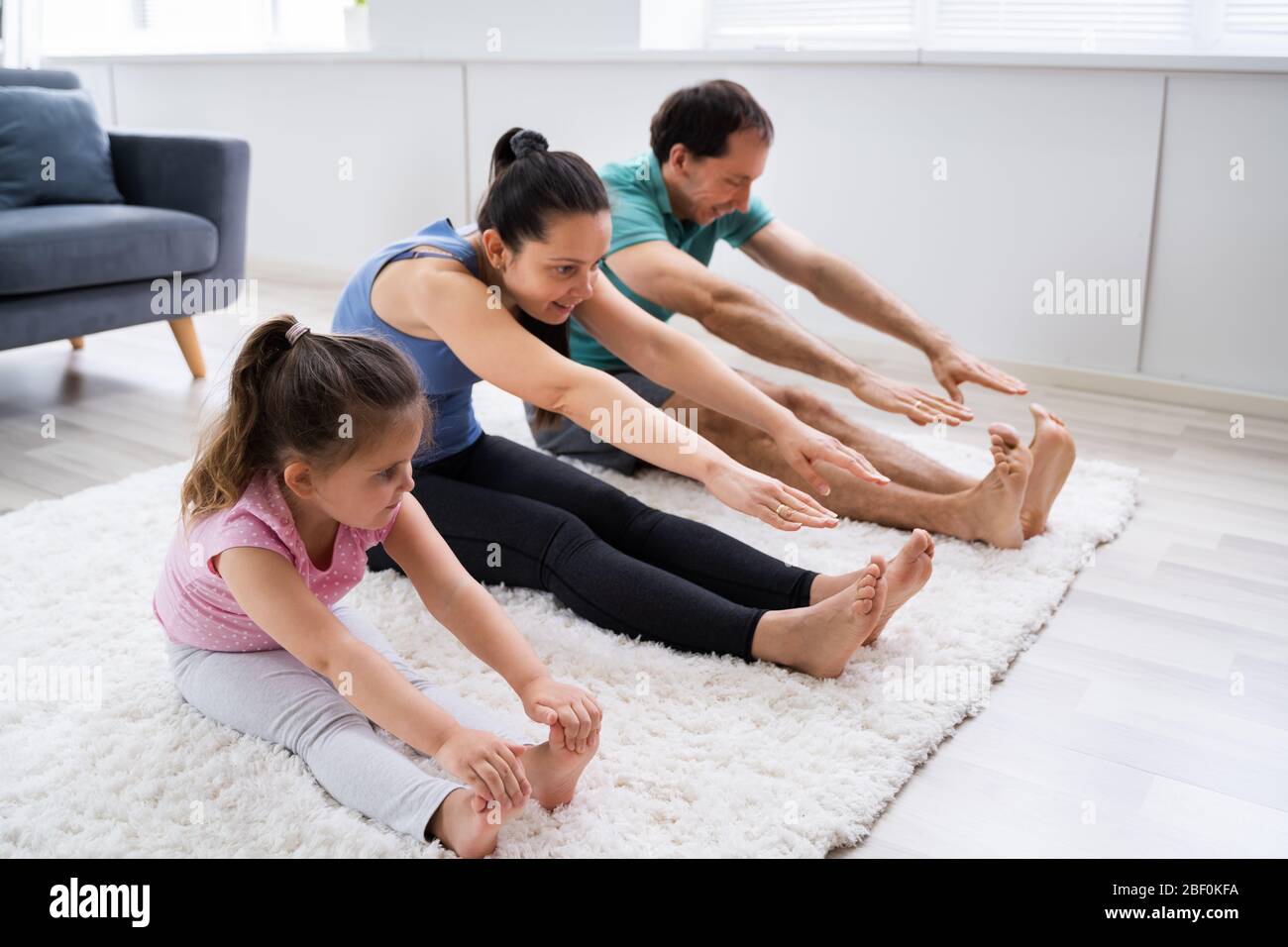 Family Doing Stretching Yoga Exercise At Home Stock Photo - Alamy