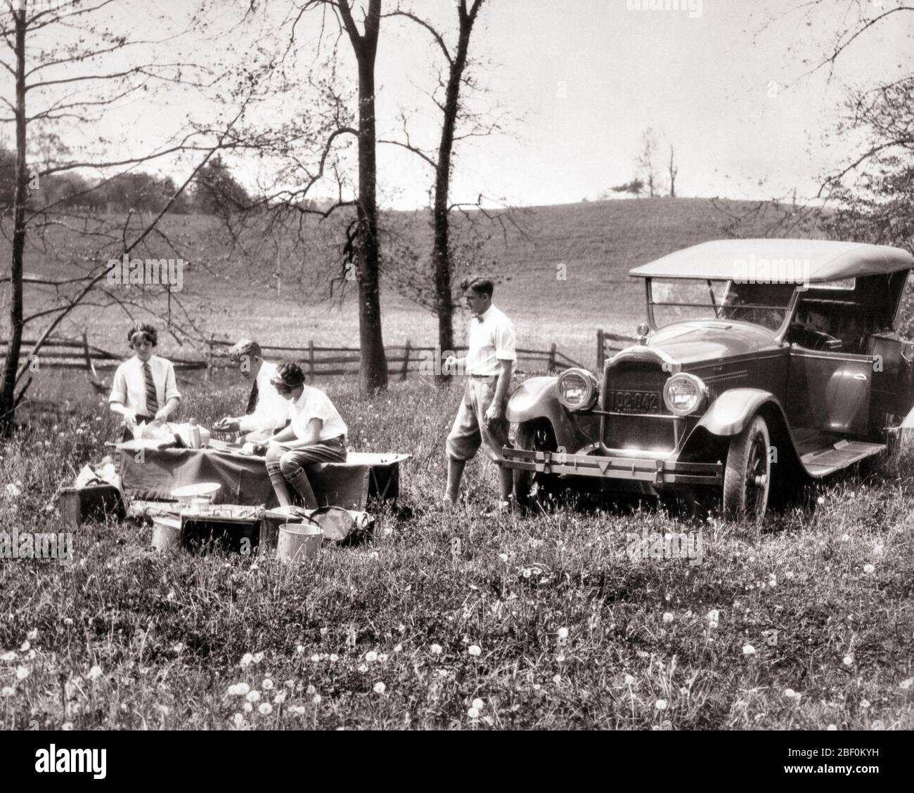 1920s GROUP OF FRIENDS TWO COUPLES MEN WOMEN ENJOYING PICNIC IN RURAL ...