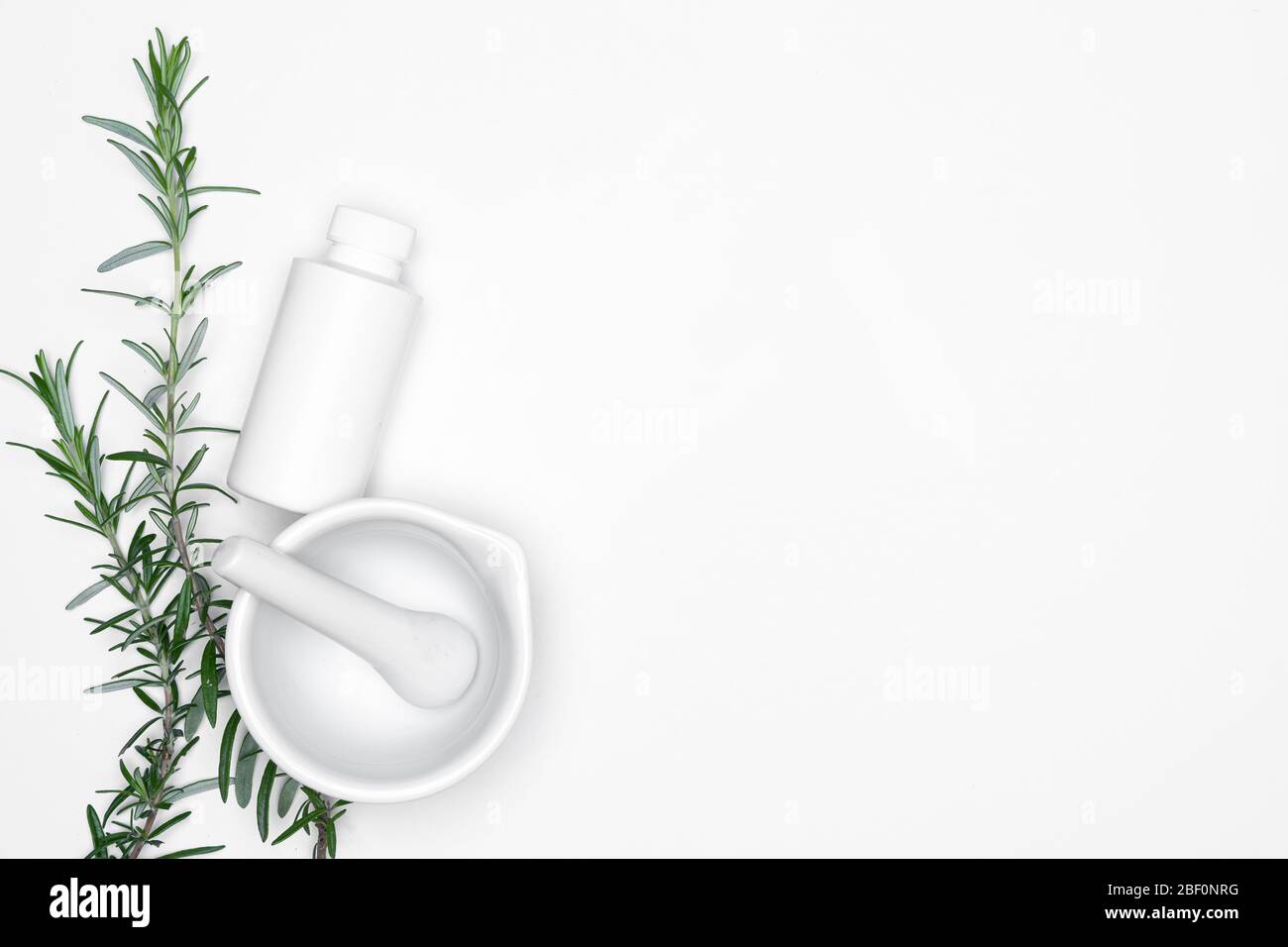 A mortar grinder drugs and white bottle with herbs - Rosemary isolated ...