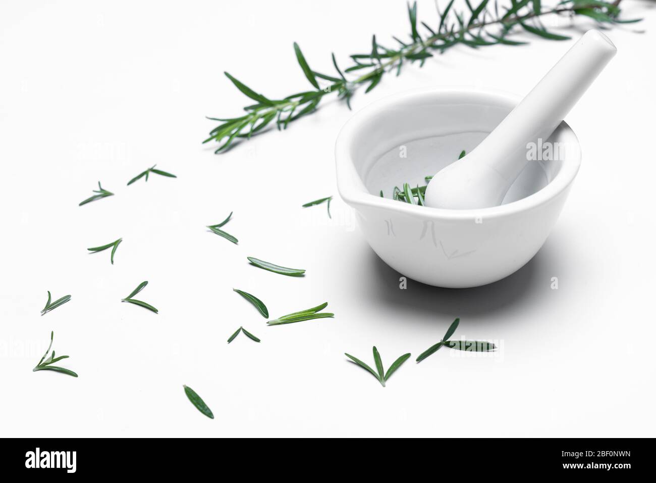 A mortar grinder drugs with herbs - Rosemary isolated on white ...