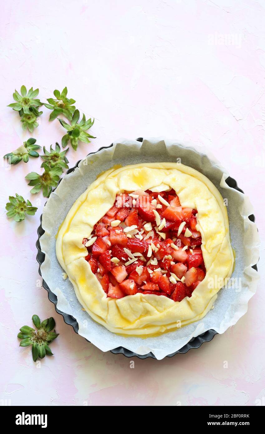 Unbaked strawberry puff pastry on white background with shades of pink ...