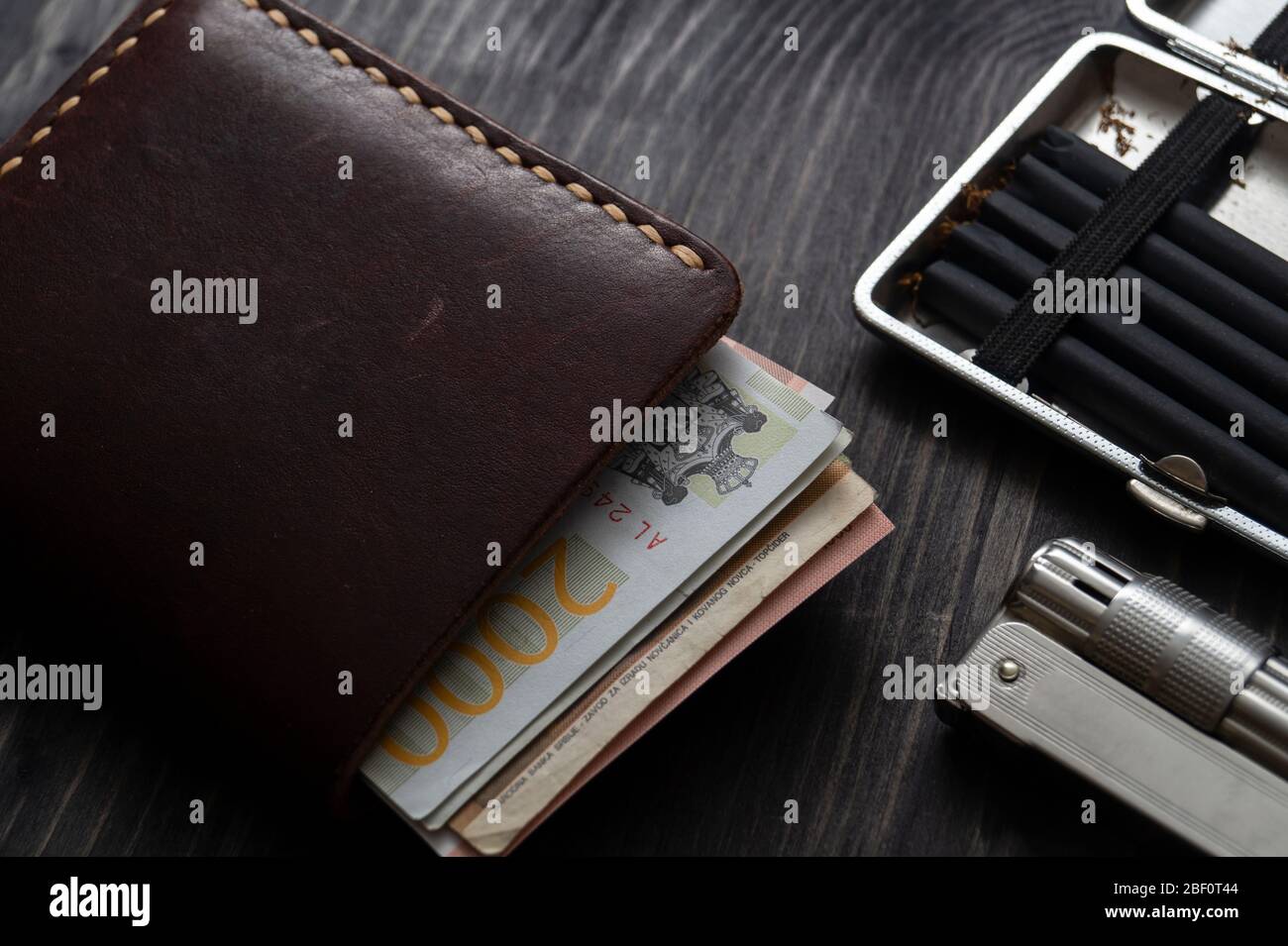 Cigarette lighter and leather wallet on a wooden background, retro ...