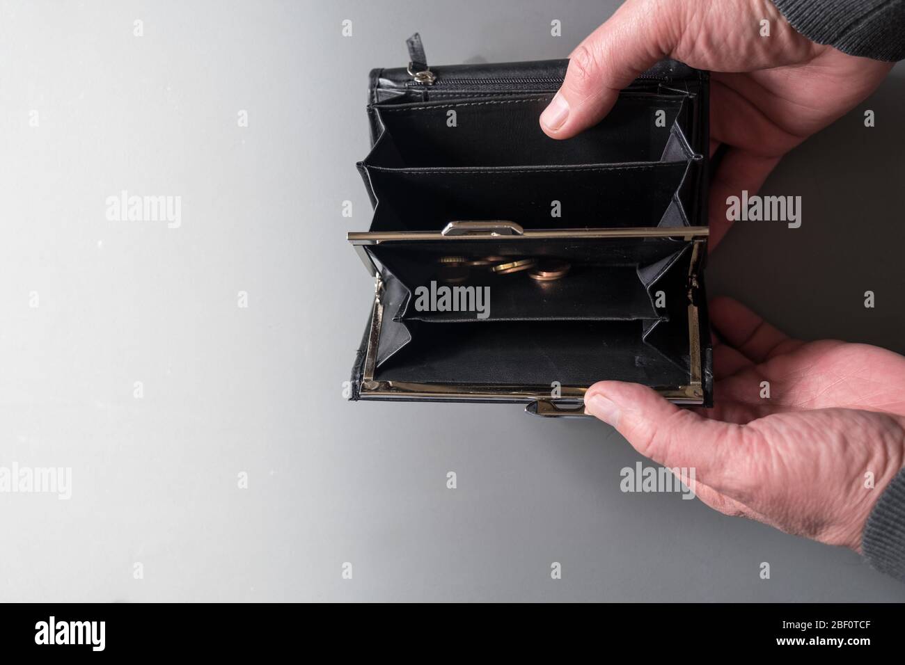 Man opens and holding empty wallet with some coins. money is over due ...