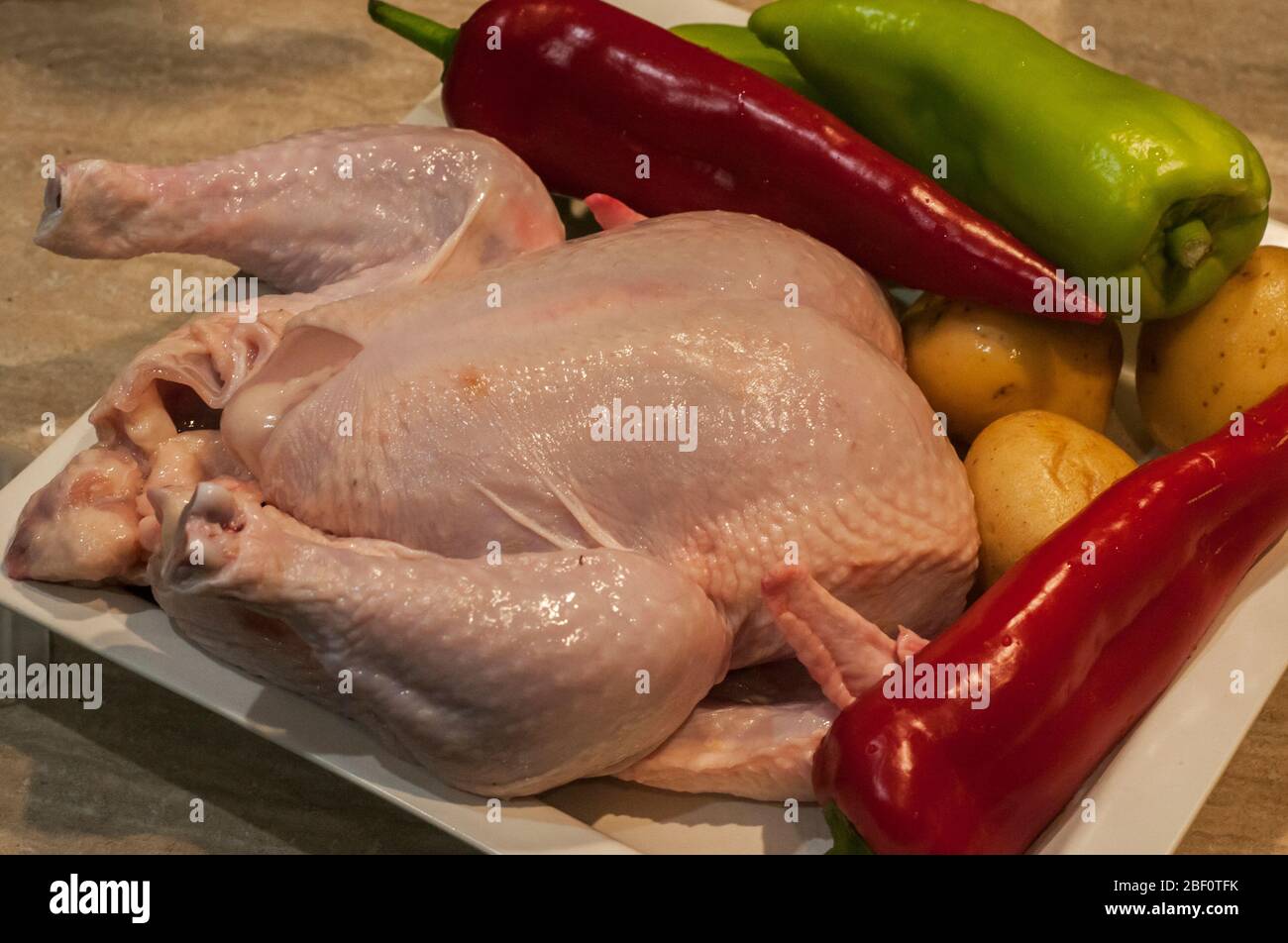 Raw chicken and vegetables closeup in white bowl ready for cooking ...