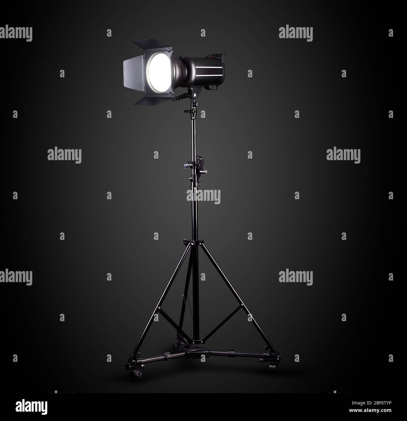 Photography studio flash on a lighting stand isolated on black ...