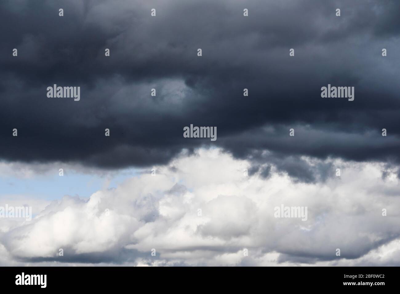 Dramatic cloudy sky, dark thundercloud over light cumulus clouds ...