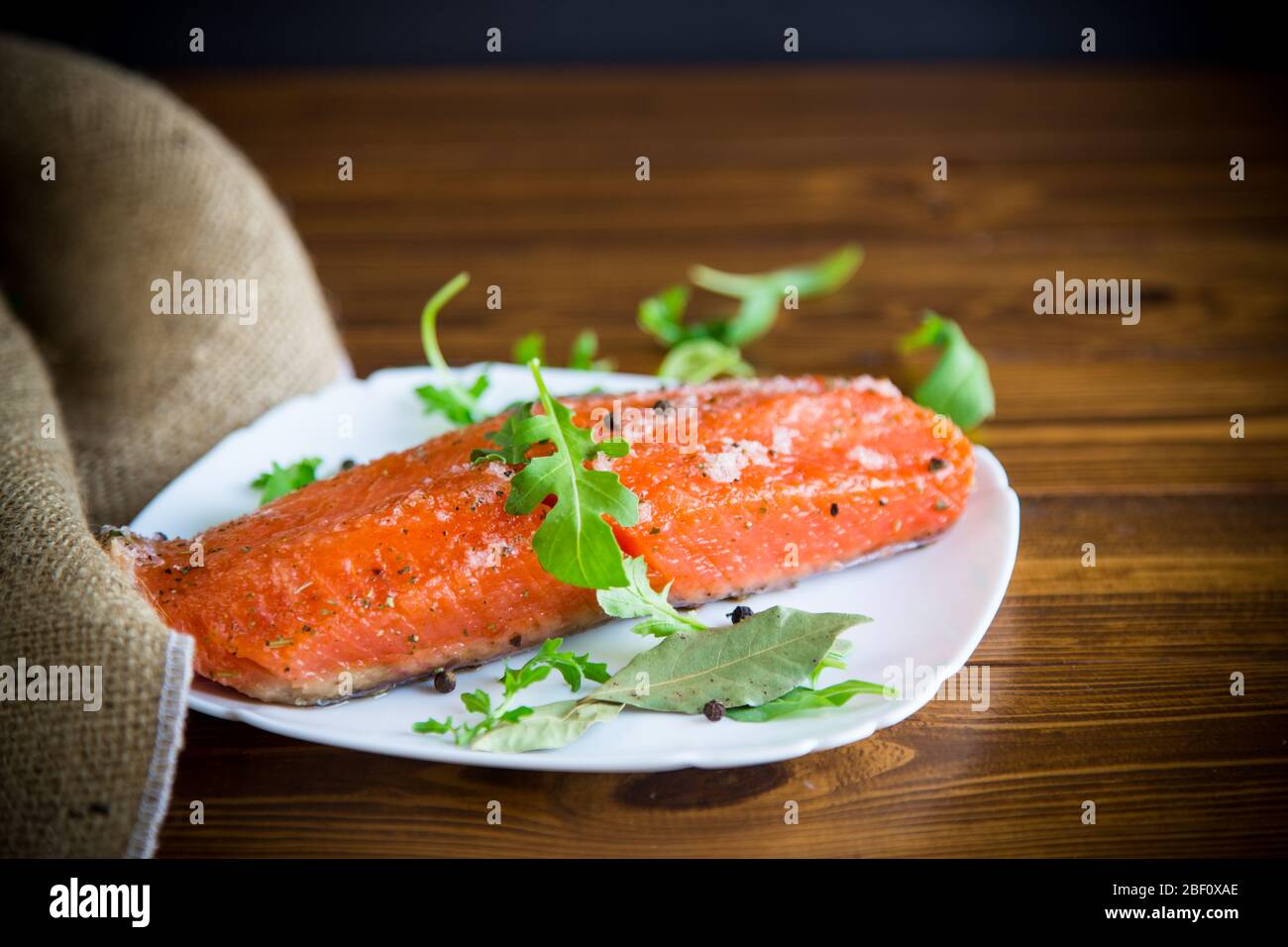 piece of salty red fish with different seasonings and herbs in a plate ...