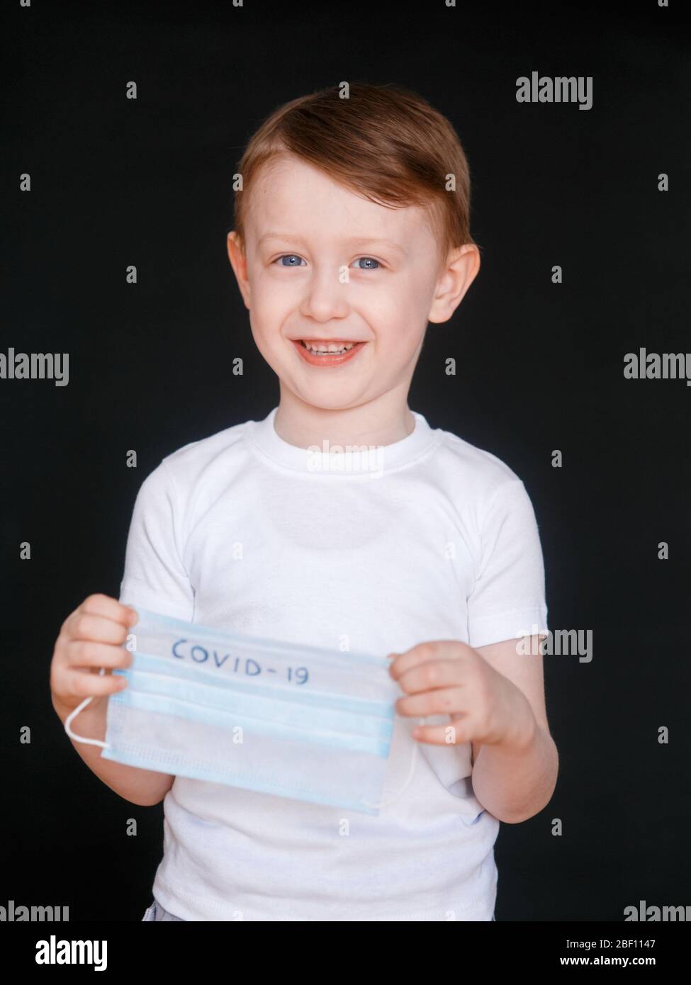 A little boy is holding a medical mask. Baby wears face masks covid-19 ...