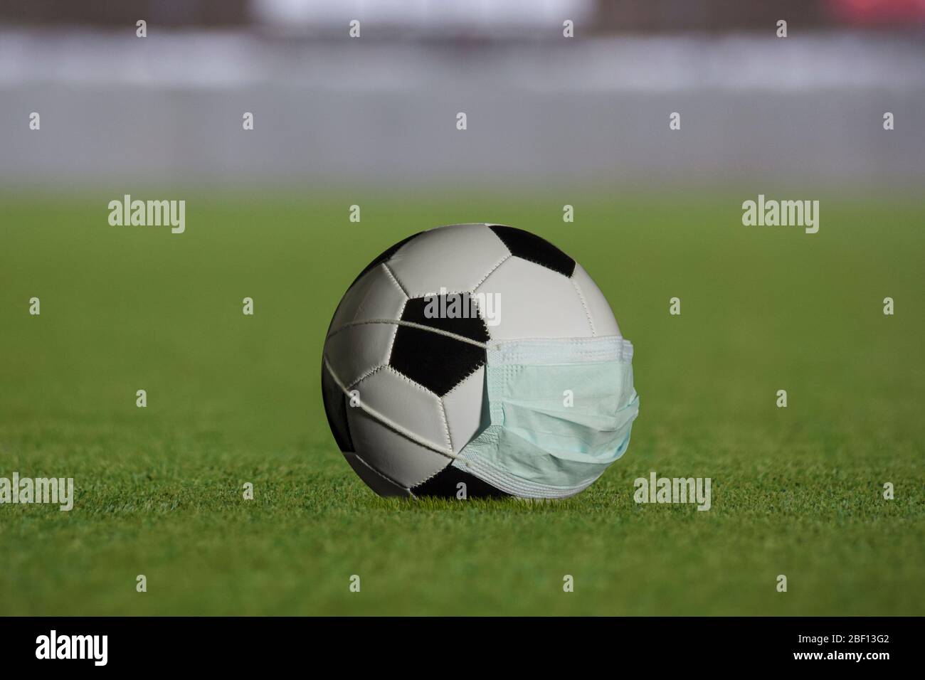 soccer ball wearing a mask, concept of sports suffering from the COVID ...