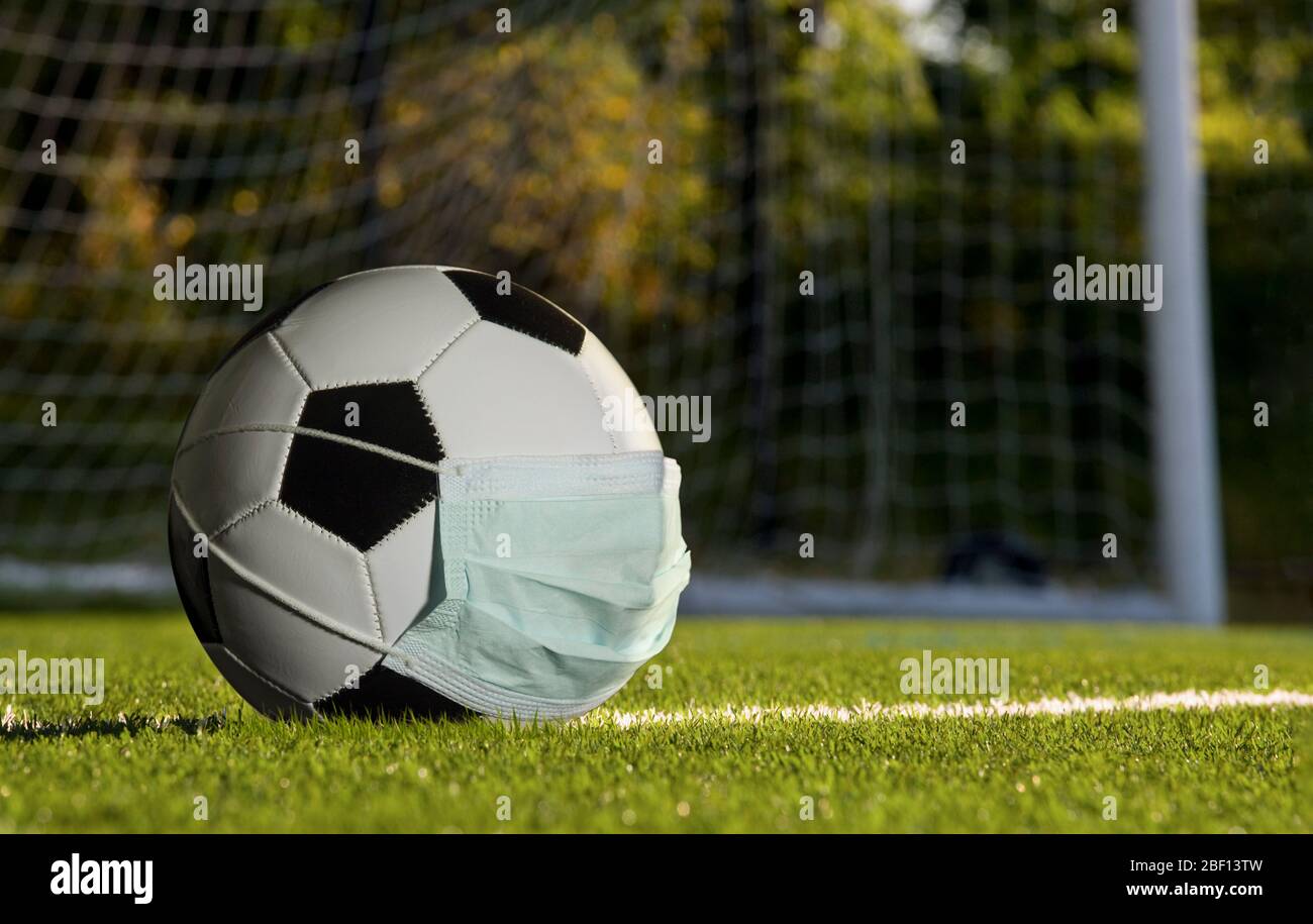 soccer ball wearing a mask, concept of sports suffering from the COVID ...